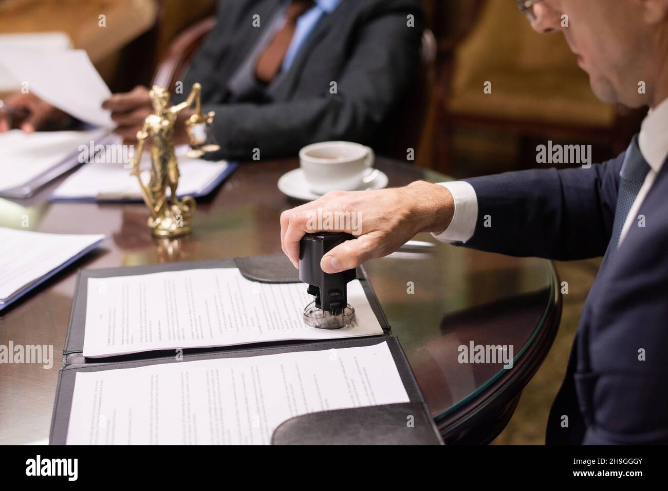 Hand of director of large business company putting stamp on document ...