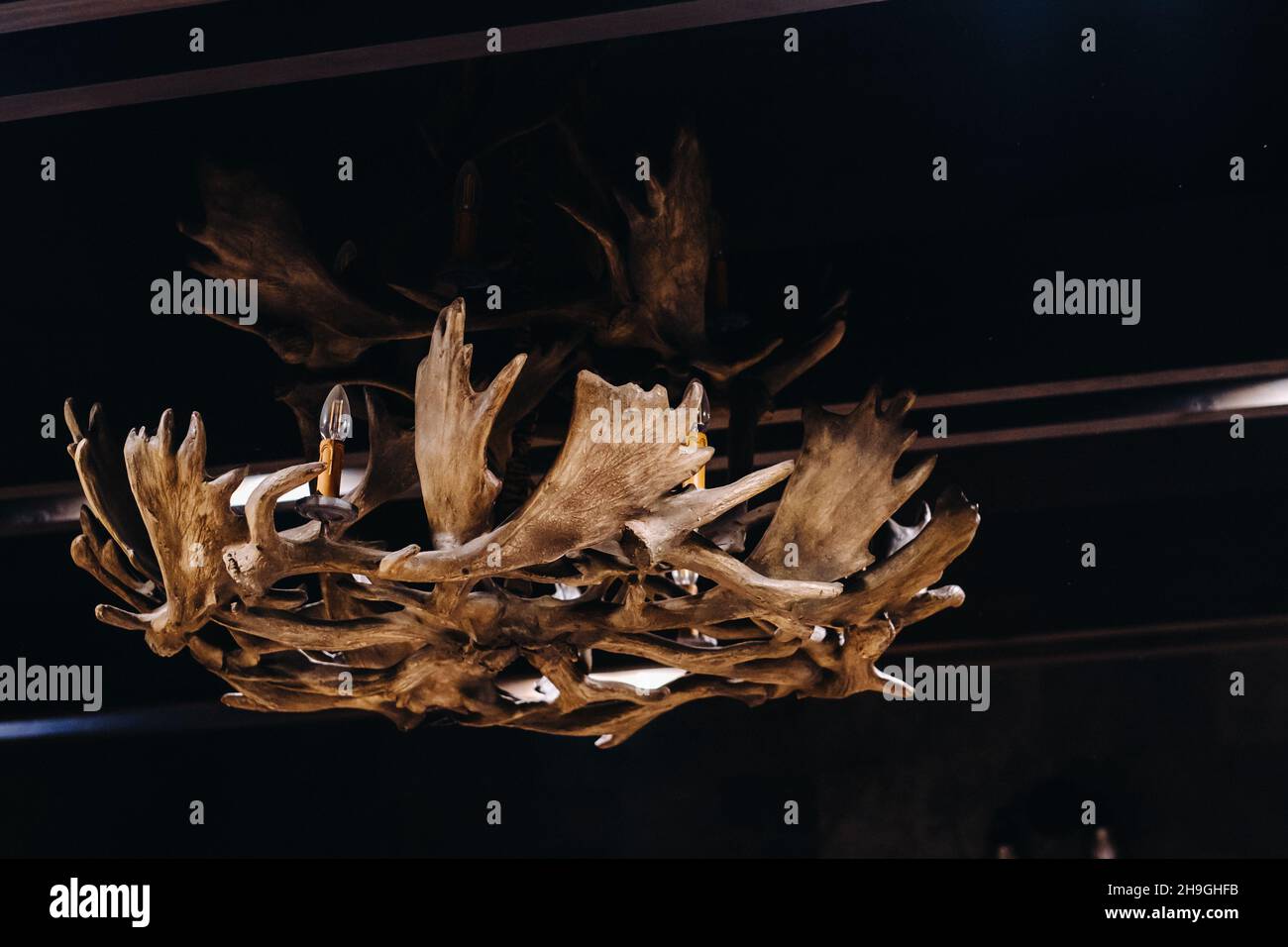 A chandelier made of deer antlers hanging on the ceiling of the ...
