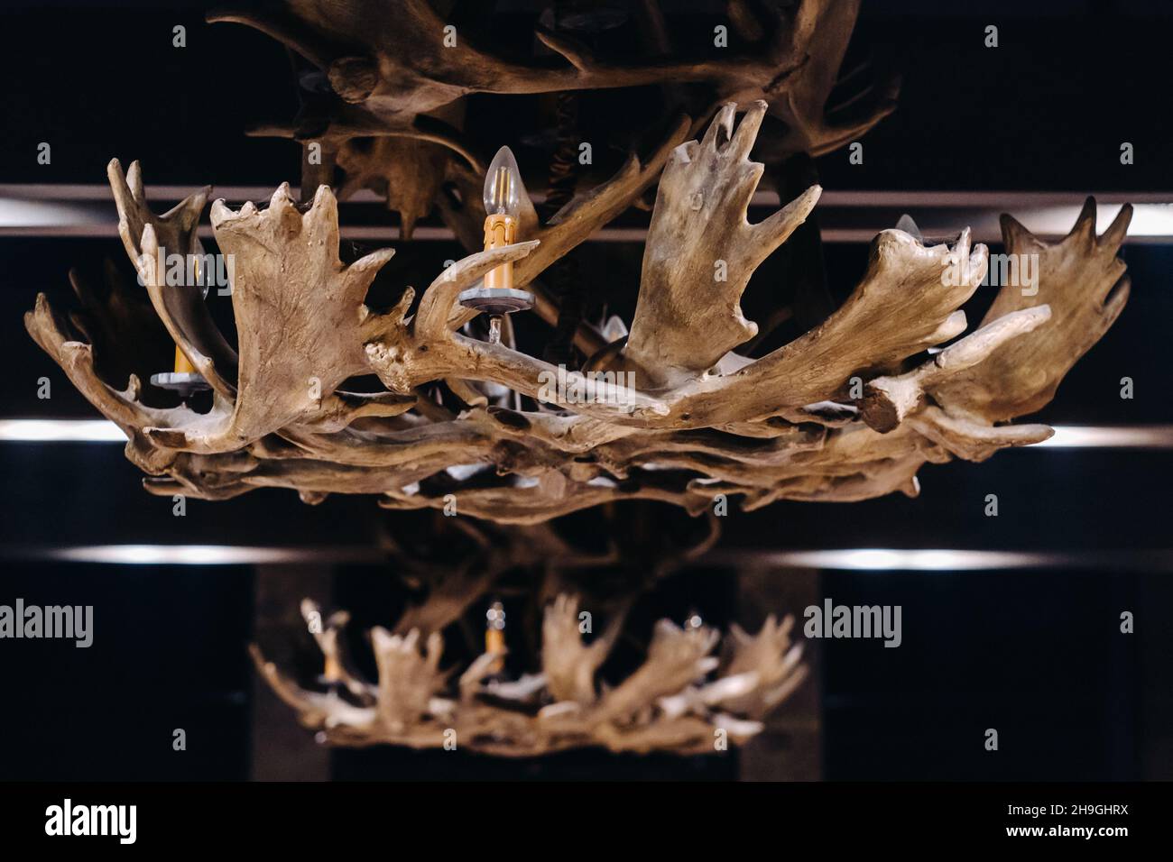 A chandelier made of deer antlers hanging on the ceiling of the ...