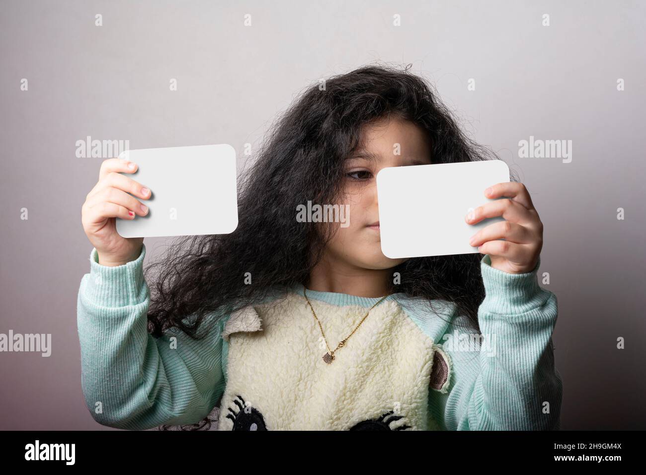 Little girl portrait holding two flash cards in hands, preschooler ...