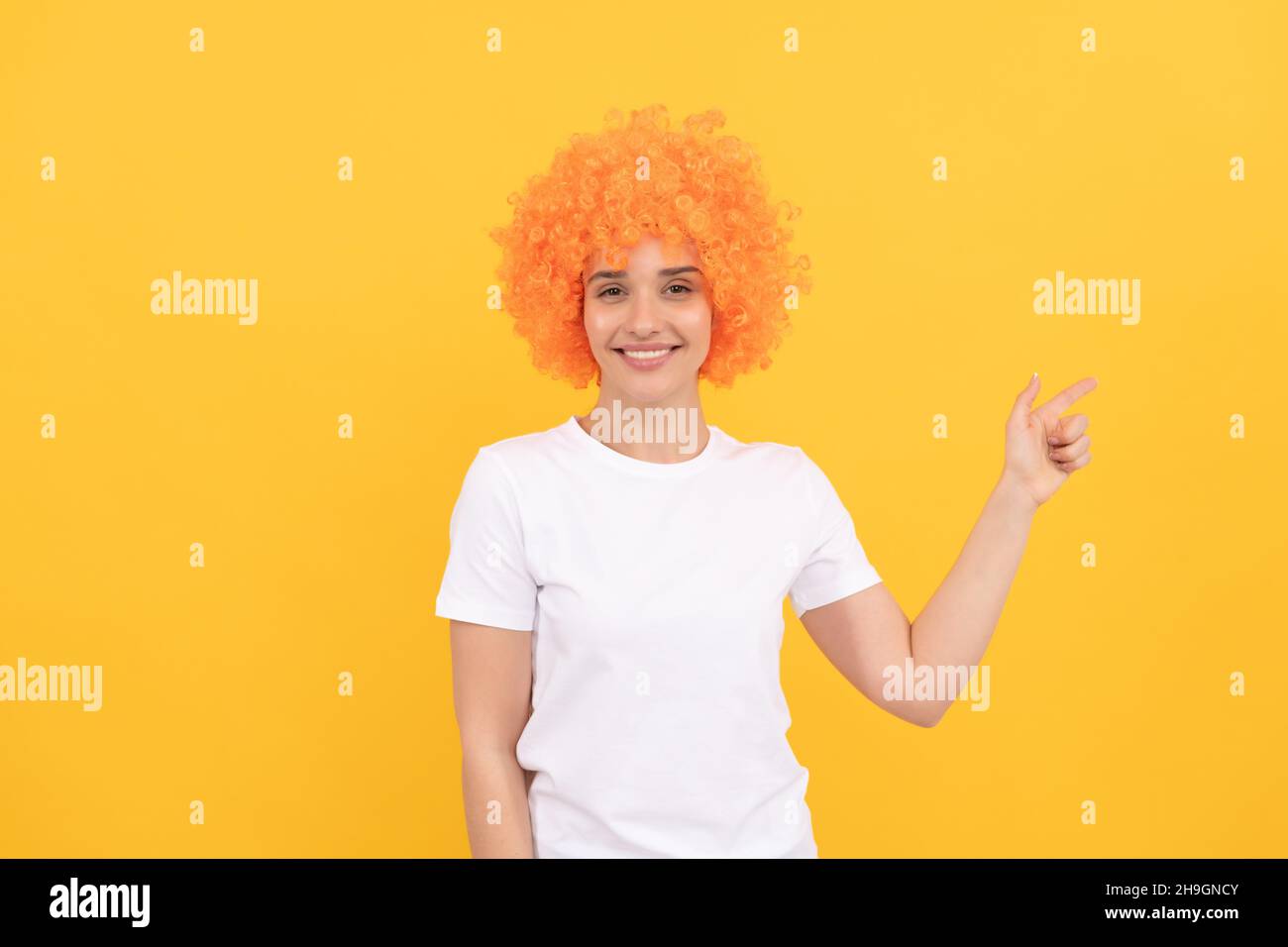 happy freaky woman in curly clown wig pointing finger, gesture and ...