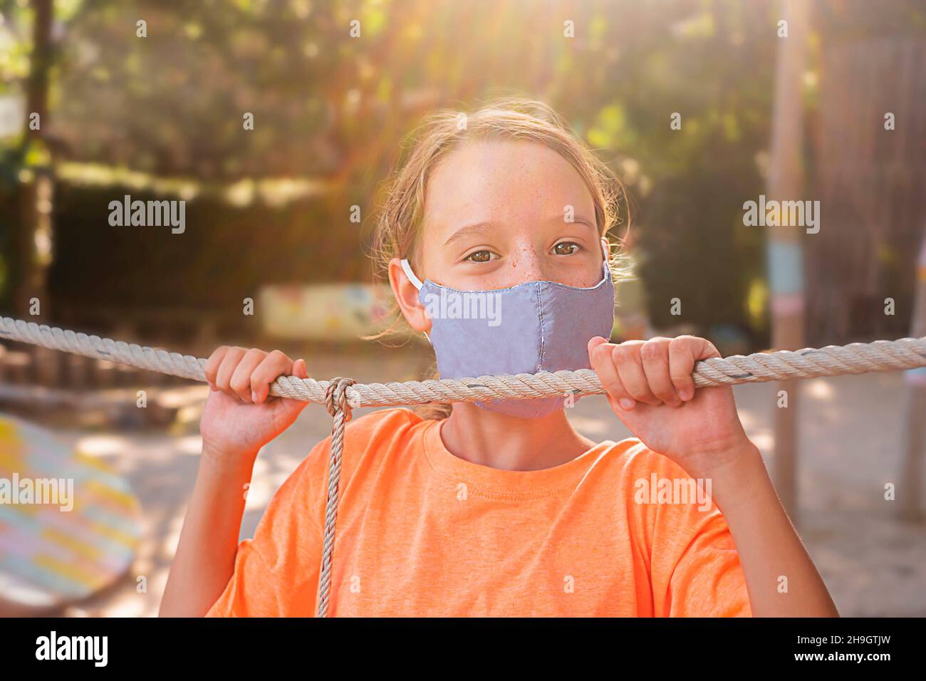 the happy child girl in the face mask on the playground Stock Photo - Alamy