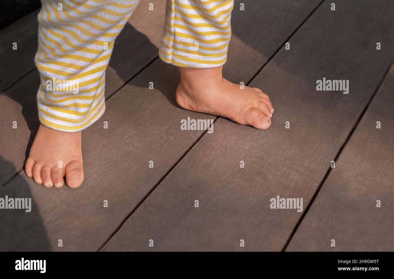 Baby's feet are taking their first steps. Baby feet on a wooden ...