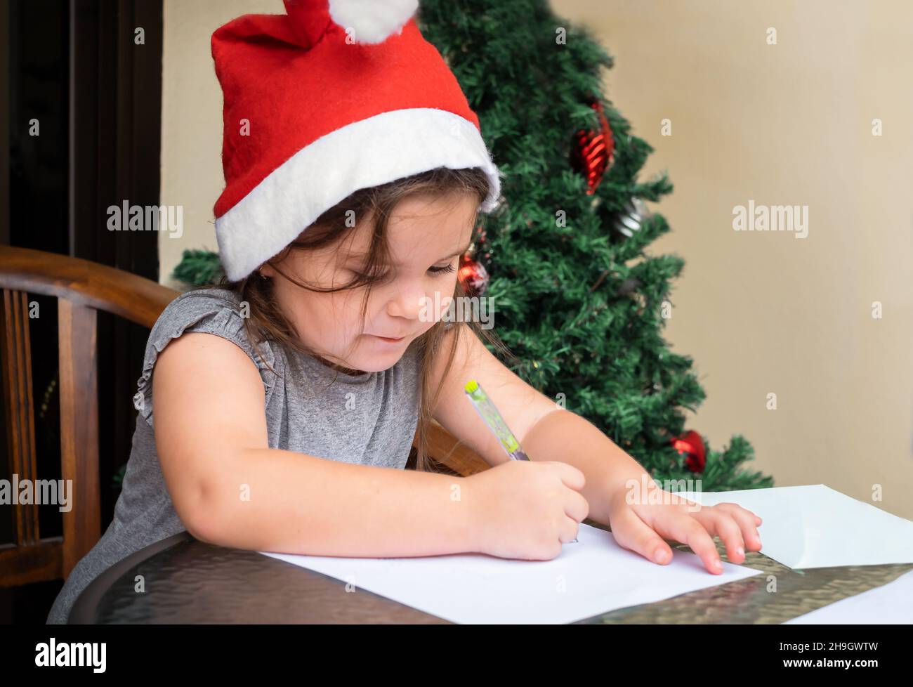 child girl writing the letter near the christmas tree Stock Photo - Alamy