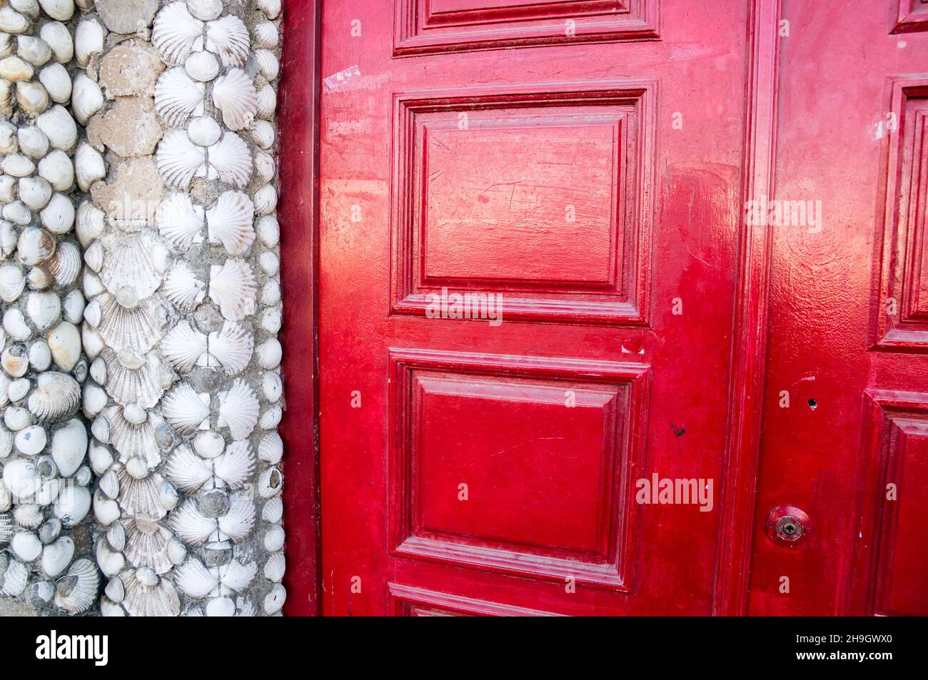 Shells wall and red door Stock Photo - Alamy