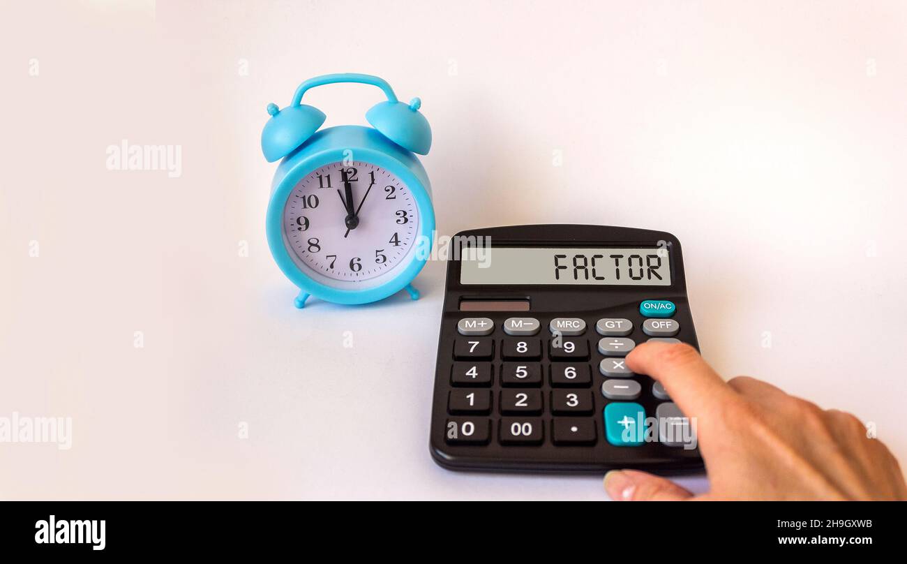Text factor on calculator and clock on white background Stock Photo - Alamy