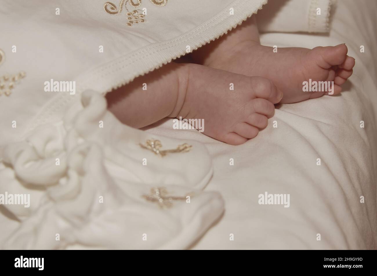 Baby's legs in the church at the baptism ceremony. Religion. Close-up ...