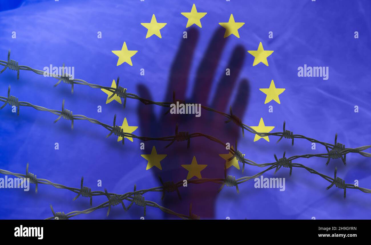 The shadow of the hand behind the barbed wire on the background of the ...