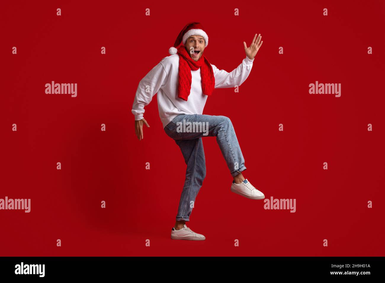 Christmas Dance. Funny Guy In Santa Hat Dancing Over Red Studio ...