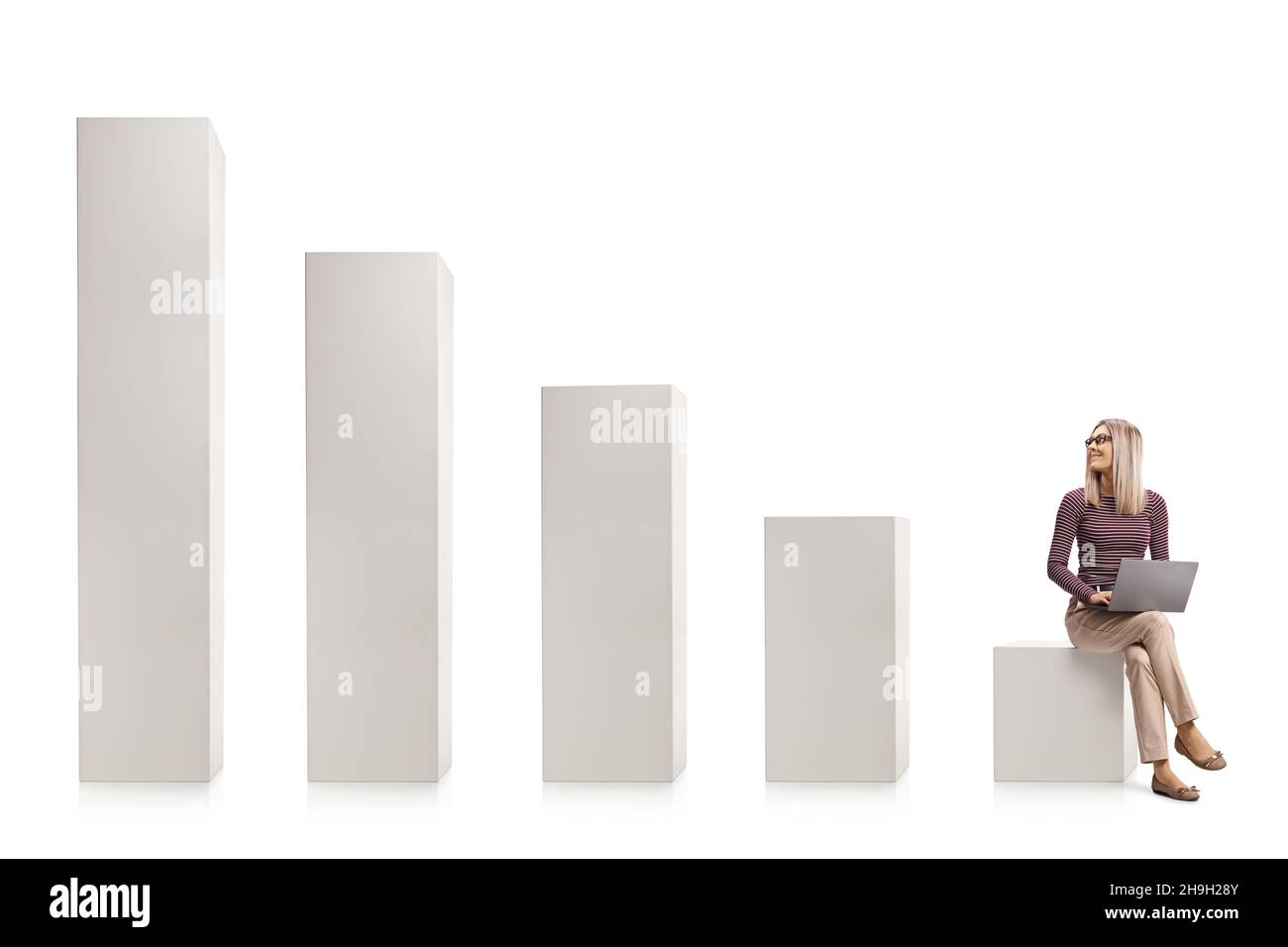 Young woman sitting on a graph chart with a laptop computer and looking ...