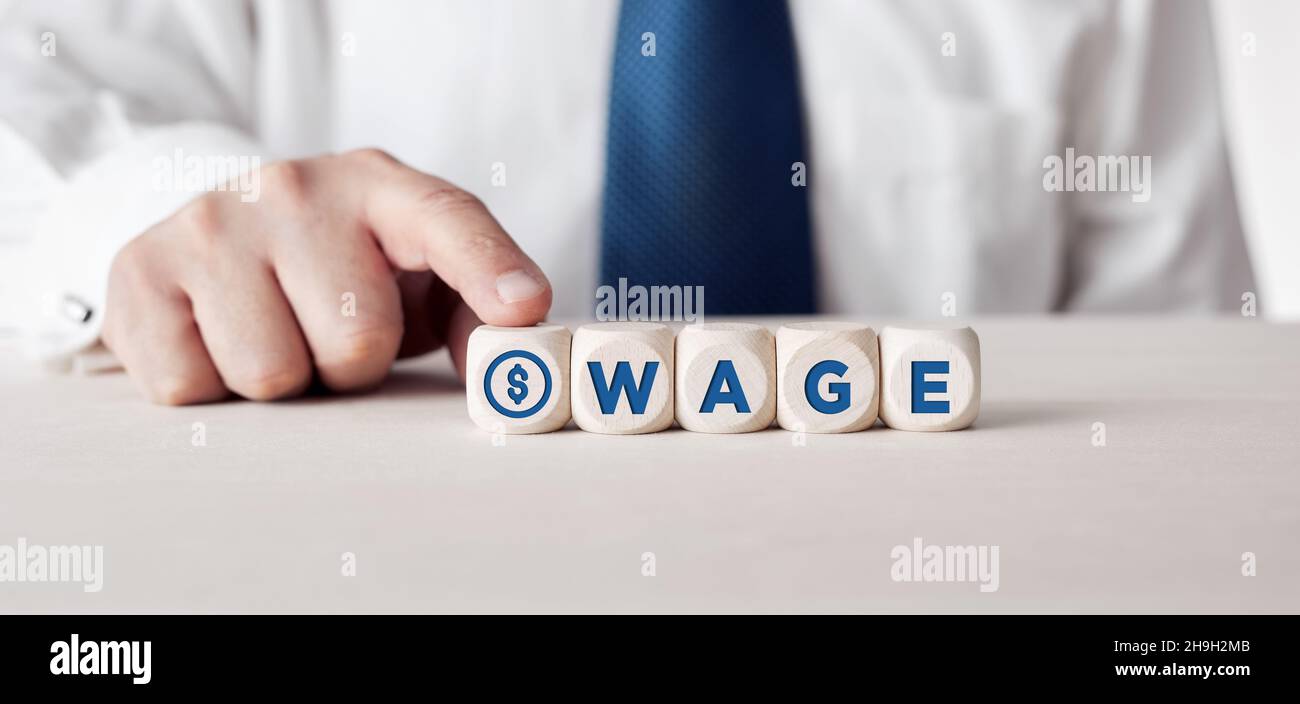 Businessperson hand showing the word wage written on wooden cubes ...