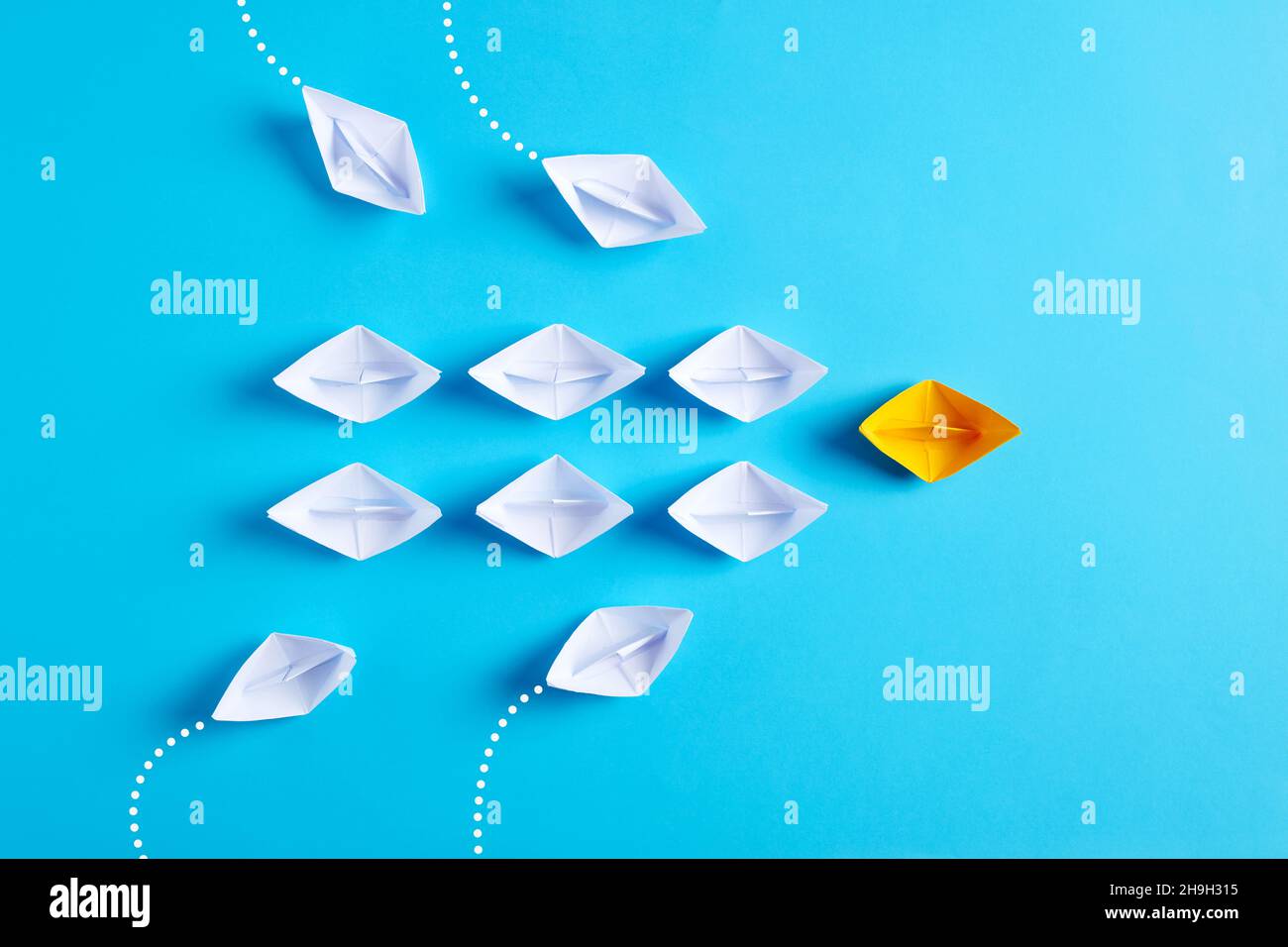 Yellow paper boat leads white paper ships with new ones joining the ...