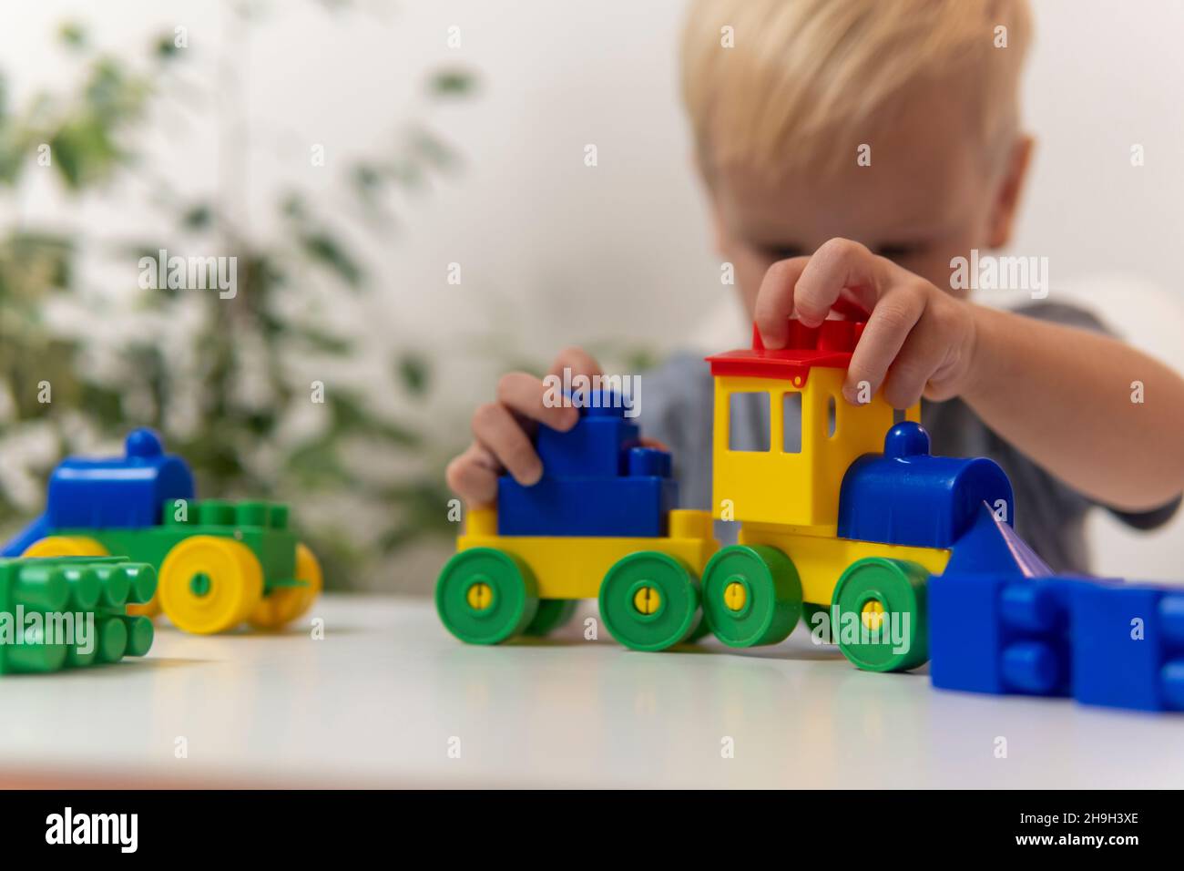 a boy carefully builds a children's train Stock Photo - Alamy