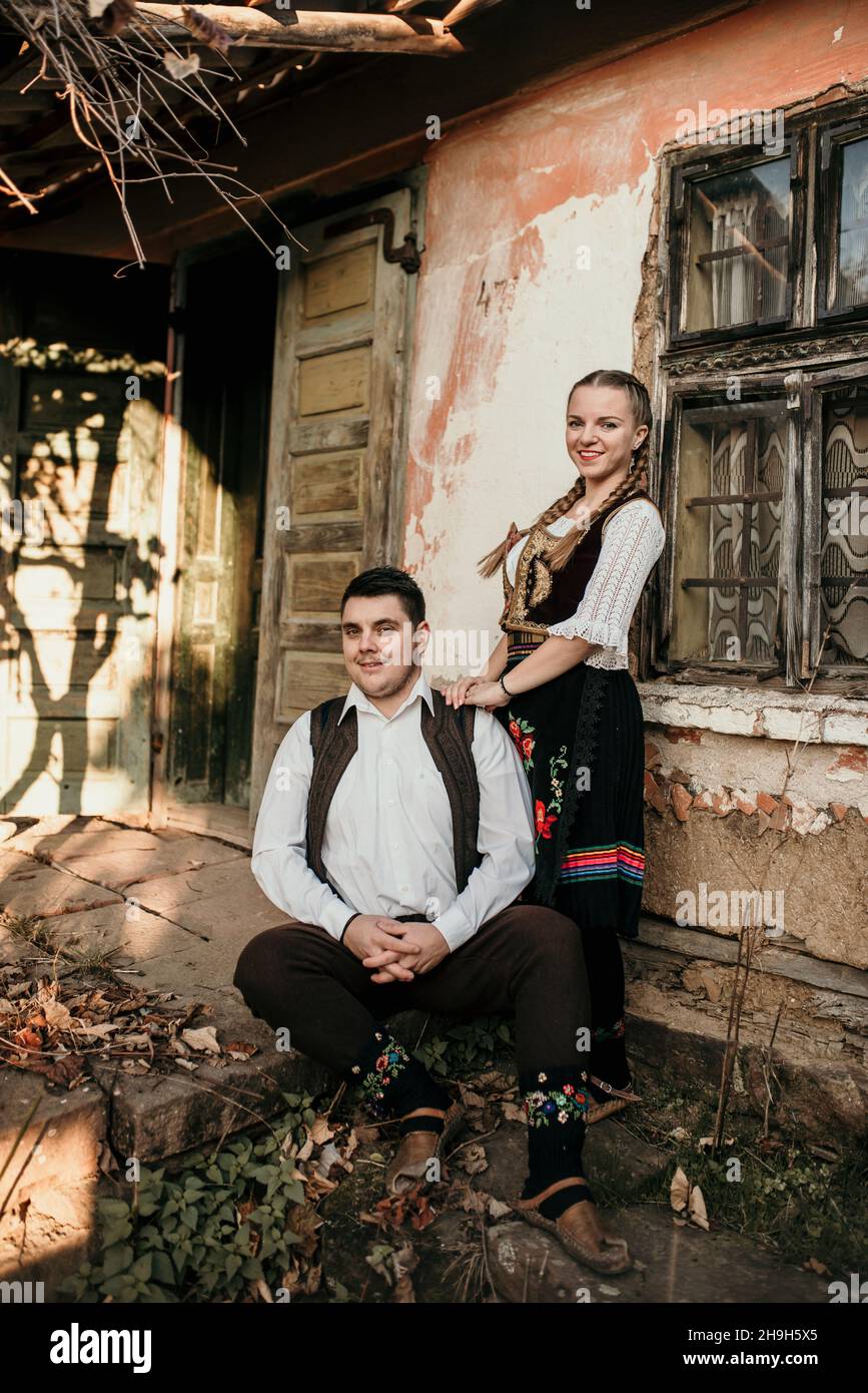 Vertical shot of a happy beautiful couple in traditional Serbian ...