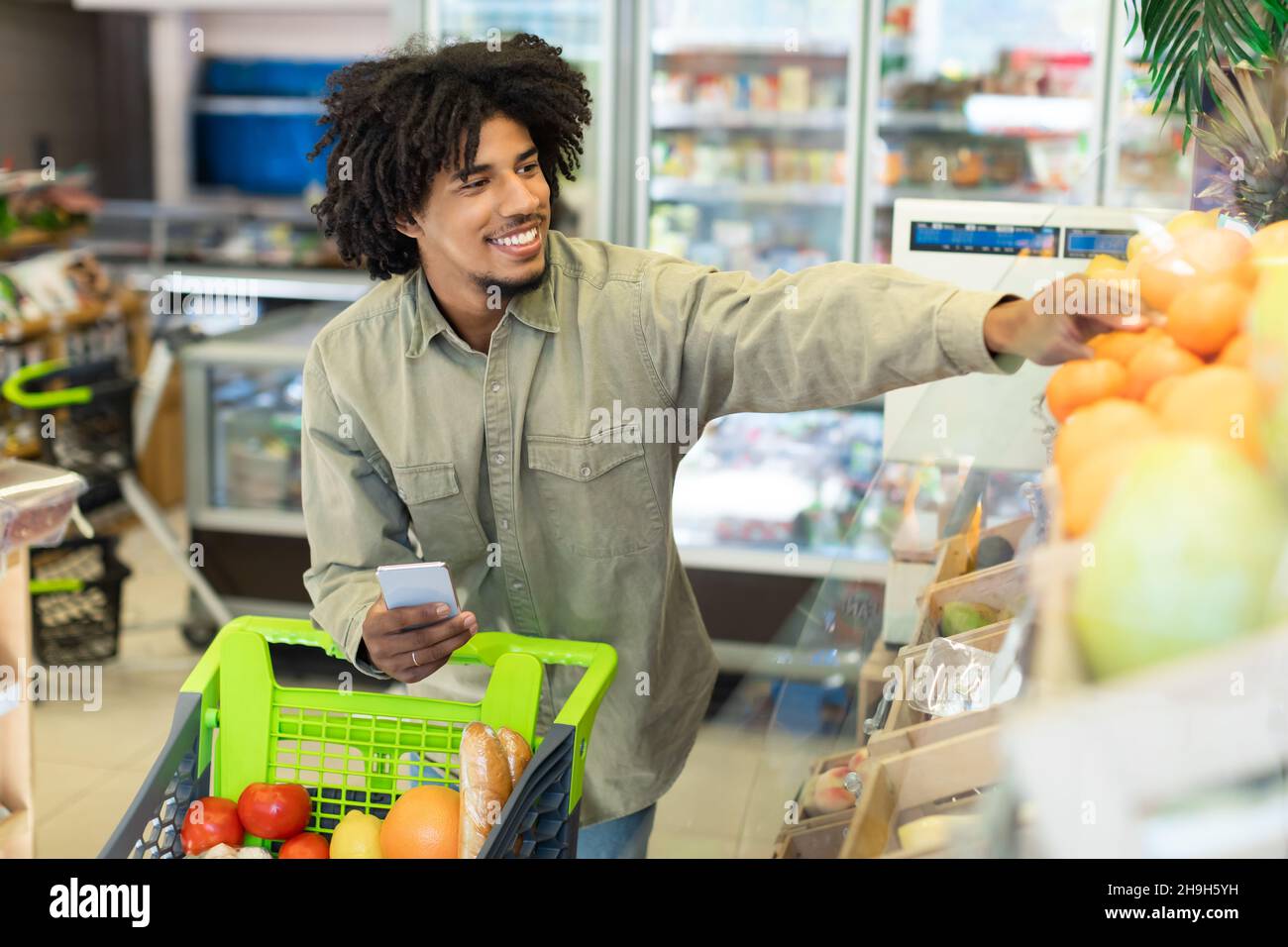 Happy African Man Using Smartphone Shopping Groceries Products In ...