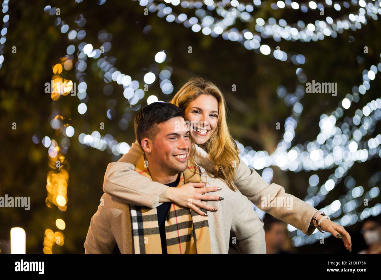 Teen couple having fun christmas x-mas at night outside. Boyfriend ...