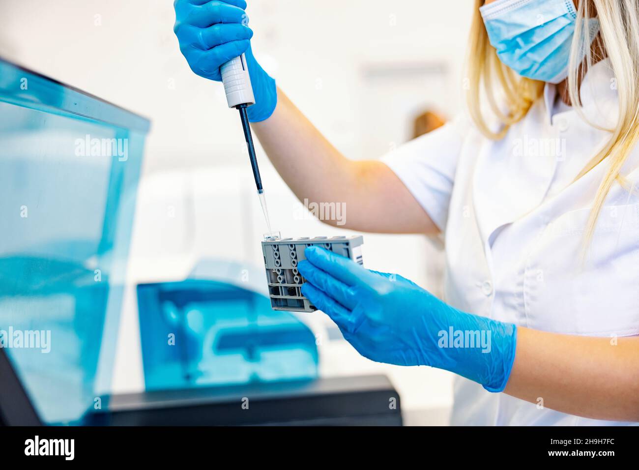 A nurse testing blood samples. A nurse is standing in the lab, holding ...
