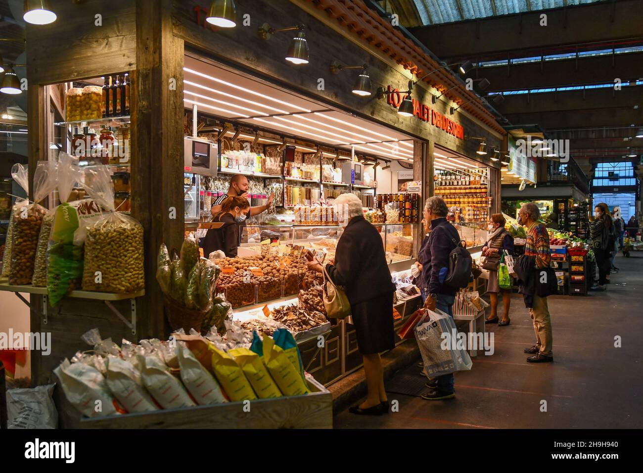People shopping at a dried fruit and spice counter in the covered ...