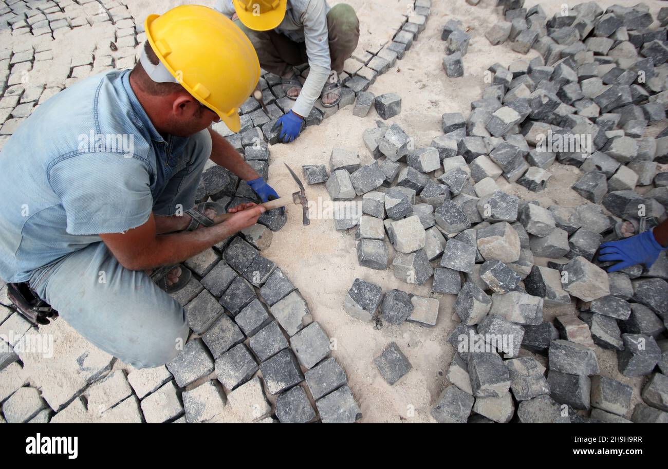 Workers laying cobblestone. Construction zone Stock Photo - Alamy