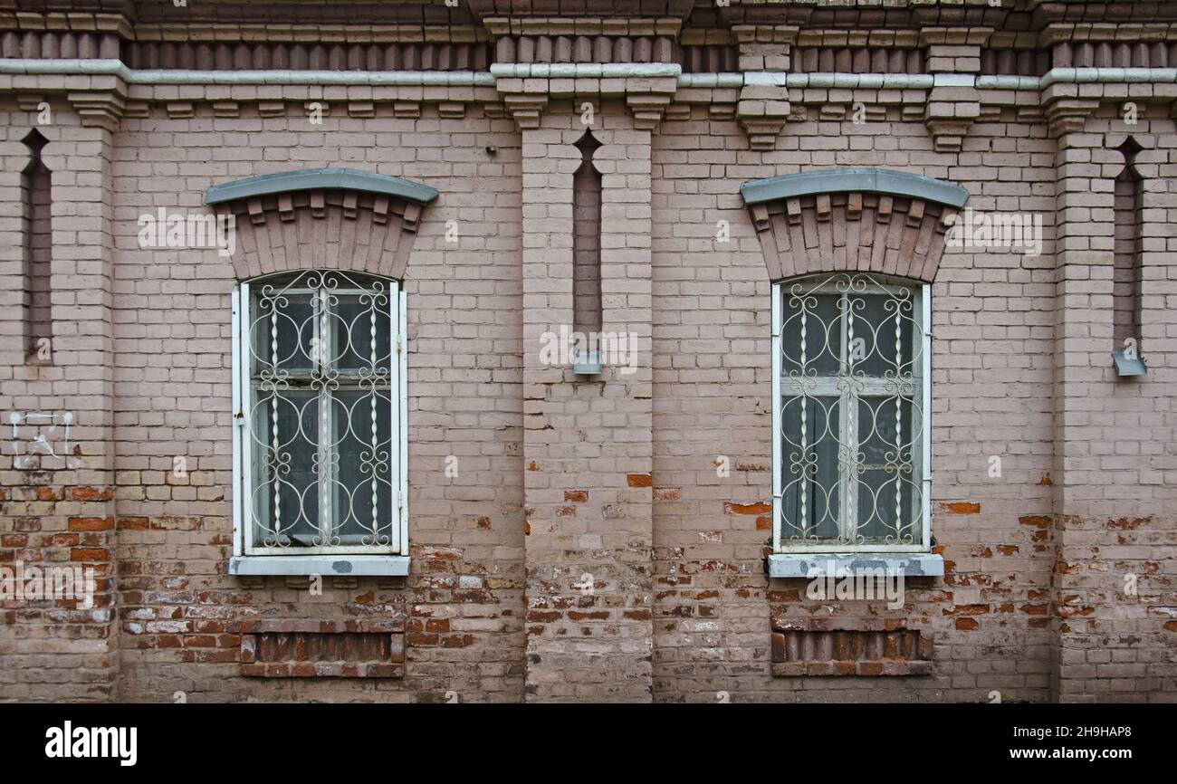 Old building facade with a brick wall and latticed windows Stock Photo ...