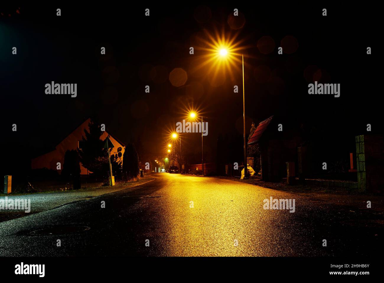 Empty rainy road at city with illuminated street lights Stock Photo - Alamy