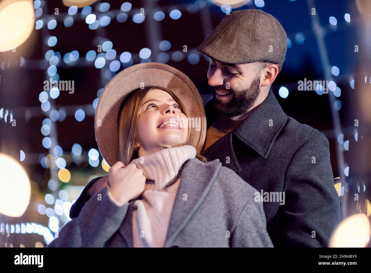 Christmas lovers hugging on the street on New Year's eve. A young happy ...