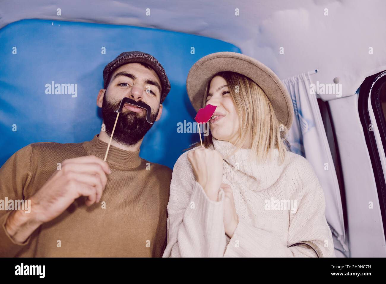 Romantic lovers goofing with the photo booth. A goofy young couple ...
