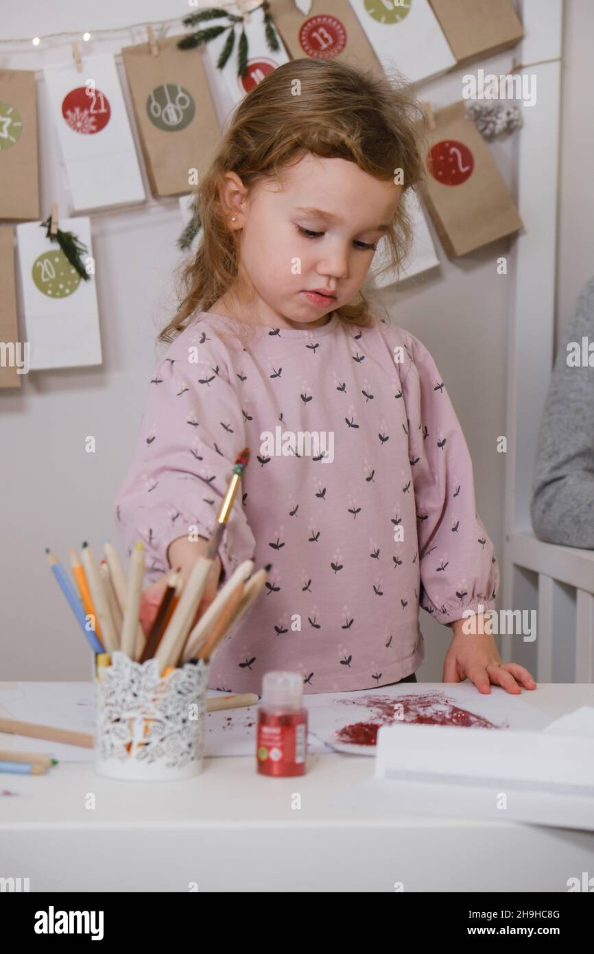 toddler child writing Christmas letter and doing advent calendar tasks ...