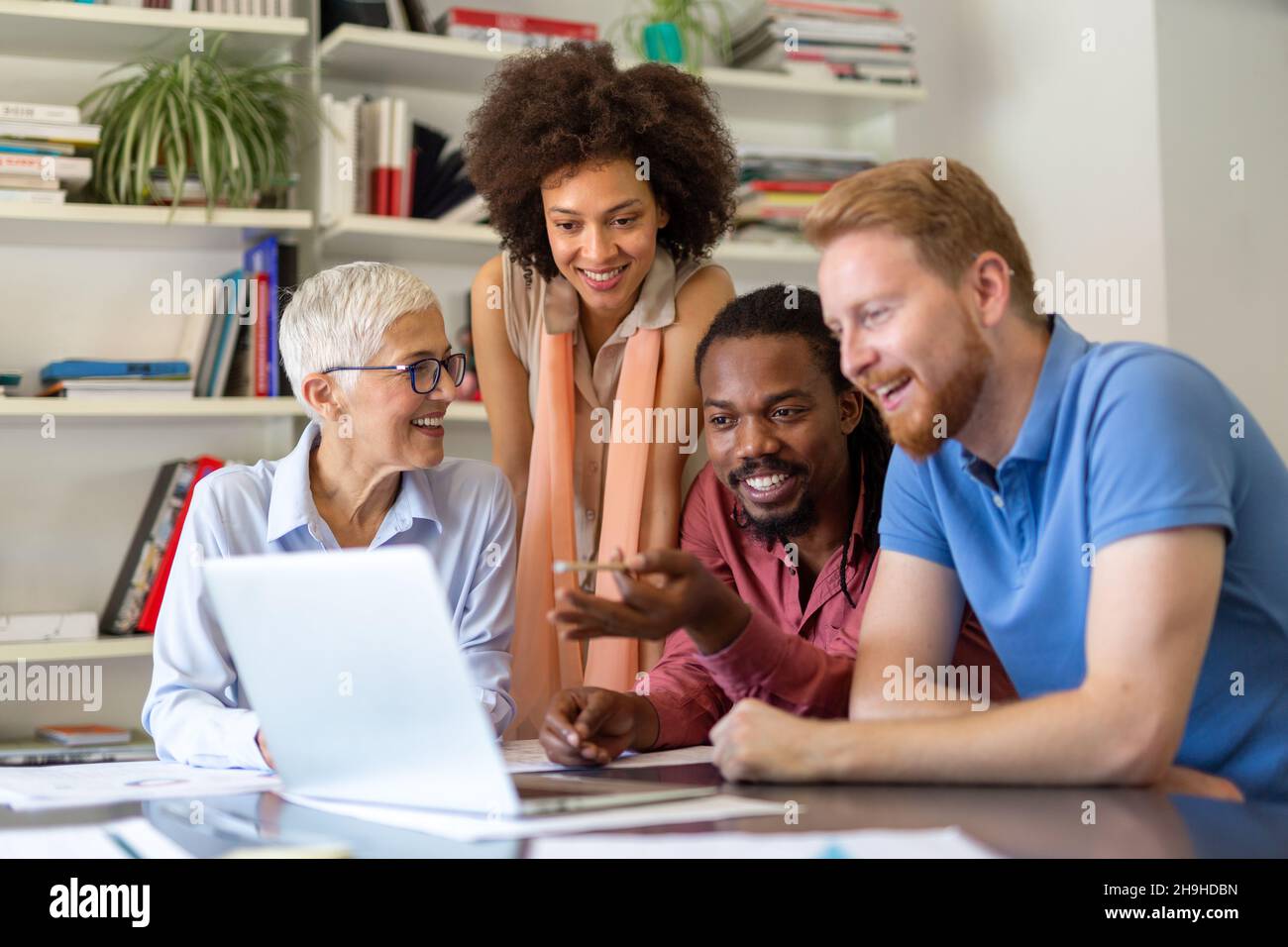 Group of happy multiethnic business people working together, sharing ideas in corporate office ...