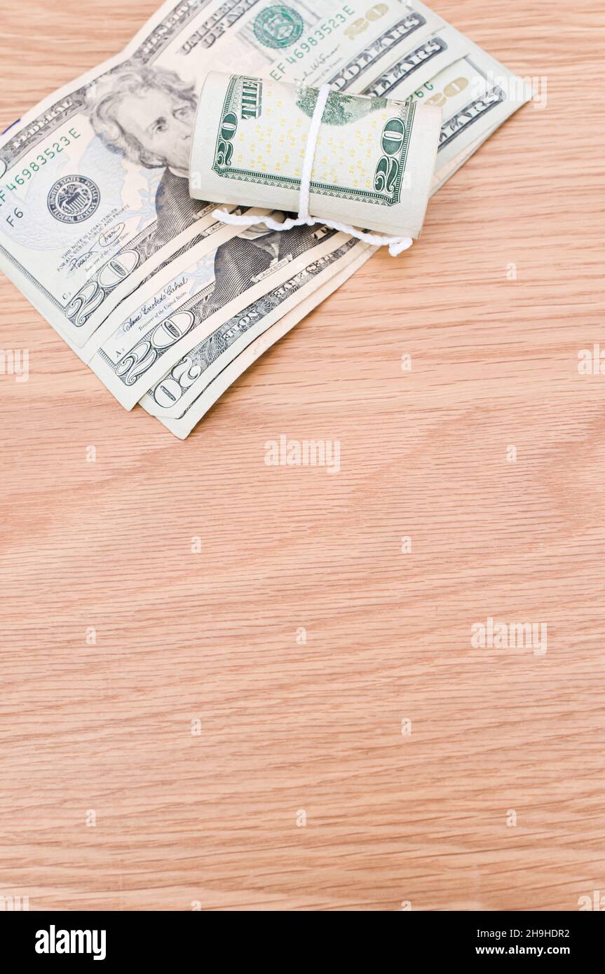 isolated US dollar banknotes roll on a wooden background with copy ...
