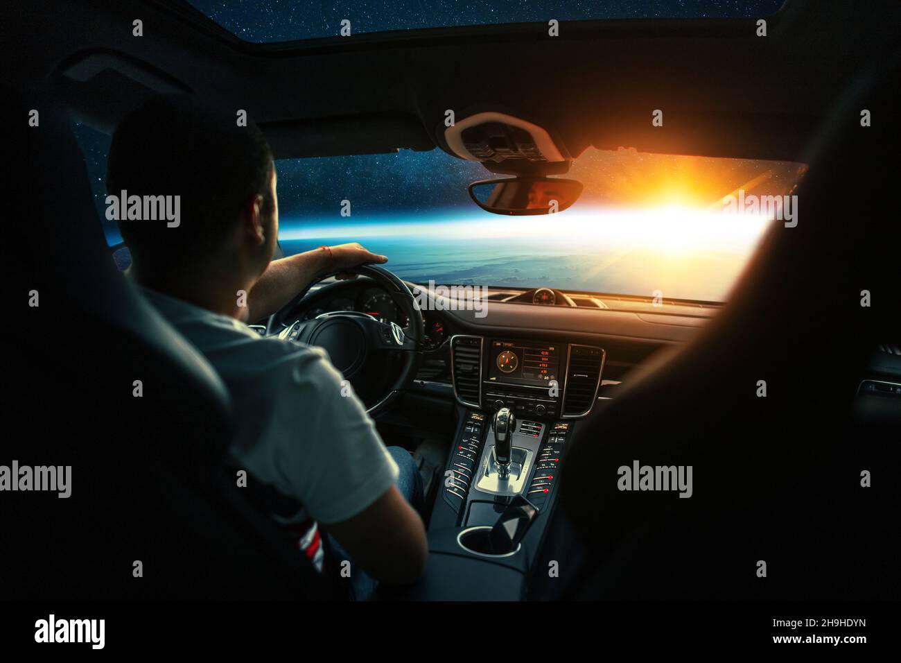 Man sits in a spaceship car and flies to the planet with a sunset in ...