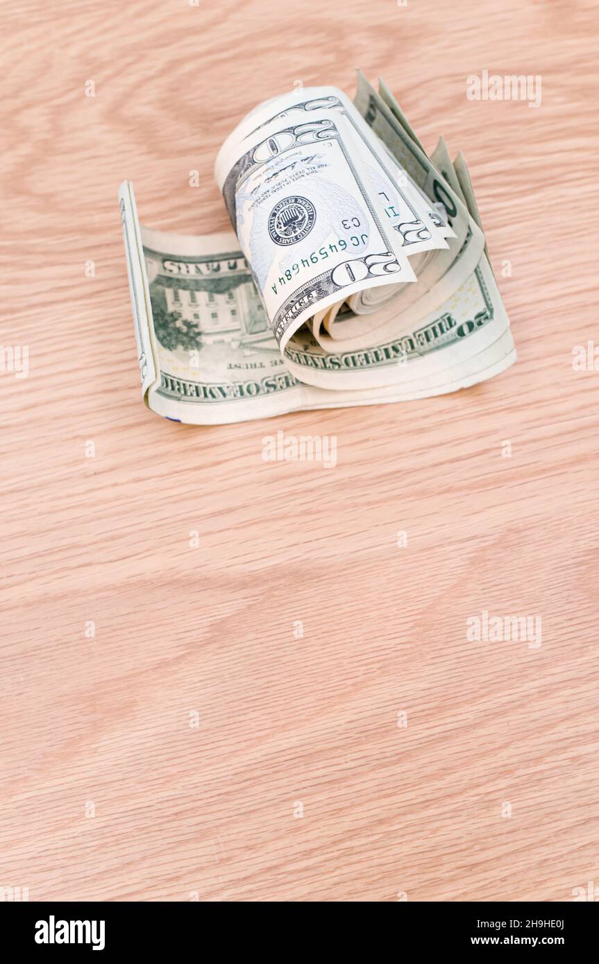 isolated US dollar banknotes roll on a wooden background with copy ...