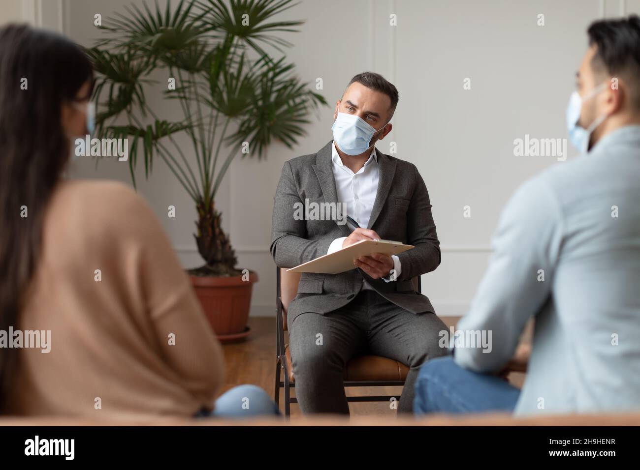 Couple having therapy session with therapist, man taking notes Stock ...