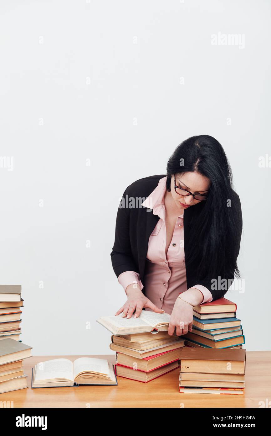 female teacher at a table with books for teaching Stock Photo - Alamy