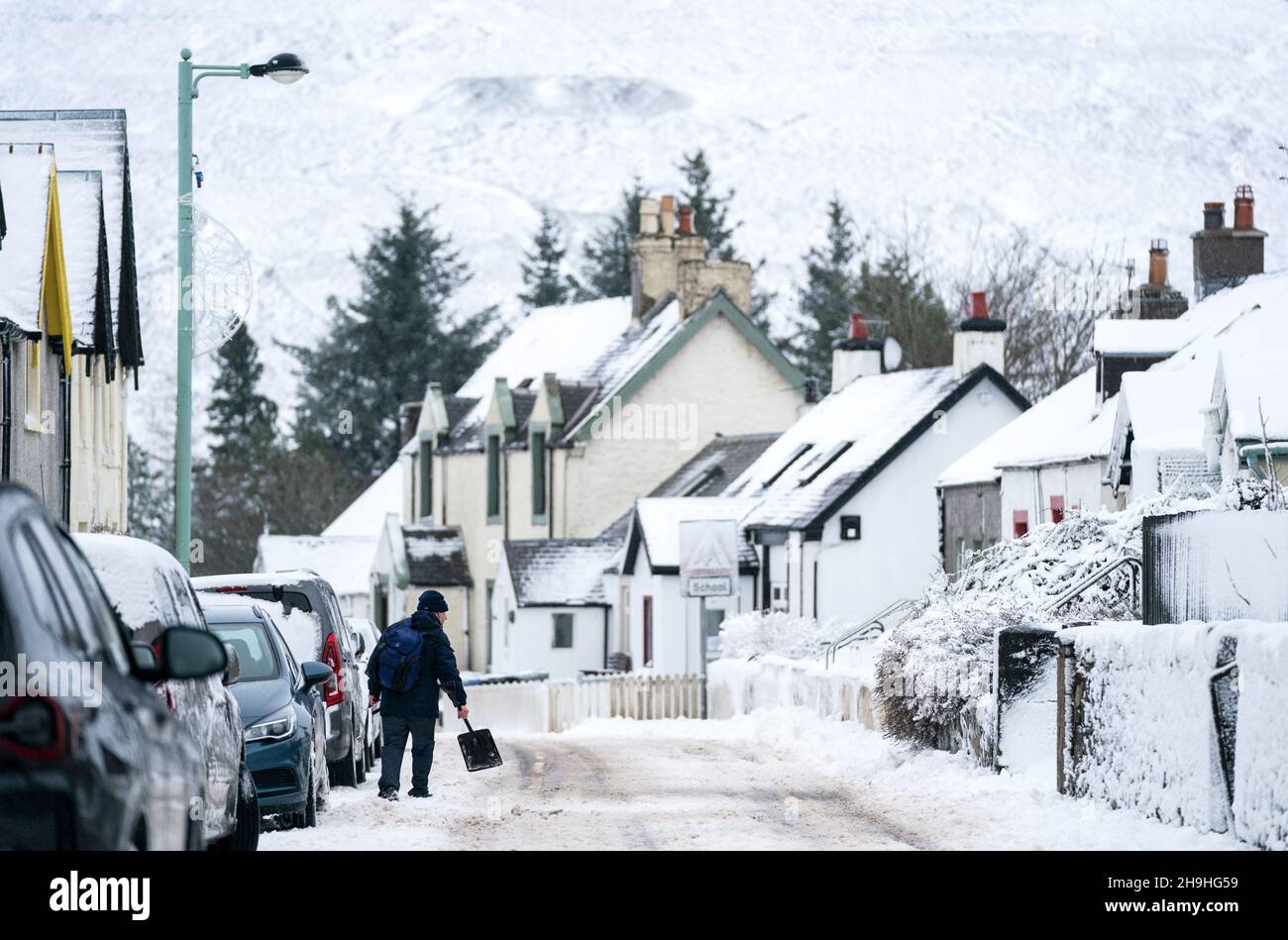 A man clears snow away in Leadhills, South Lanarkshire as Storm Barra ...