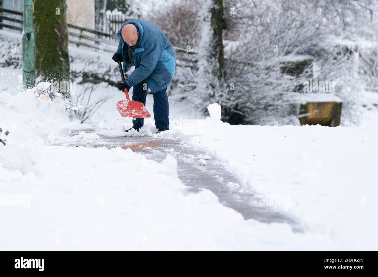 A man clears the snow in Leadhills, South Lanarkshire as Storm Barra ...