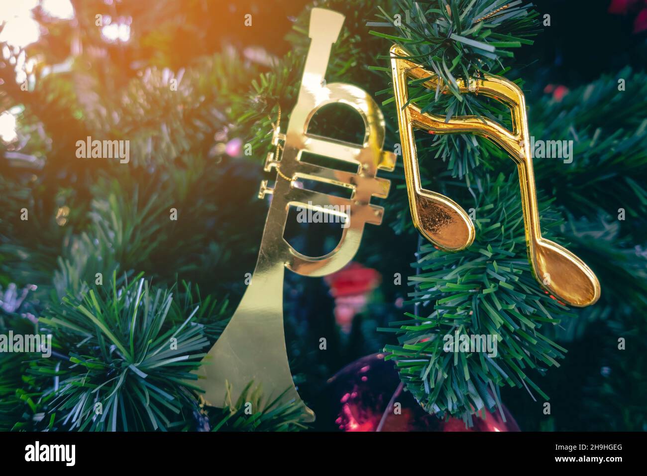 Shiny treble clef ornament or gold music notes hanging on pine tree ...