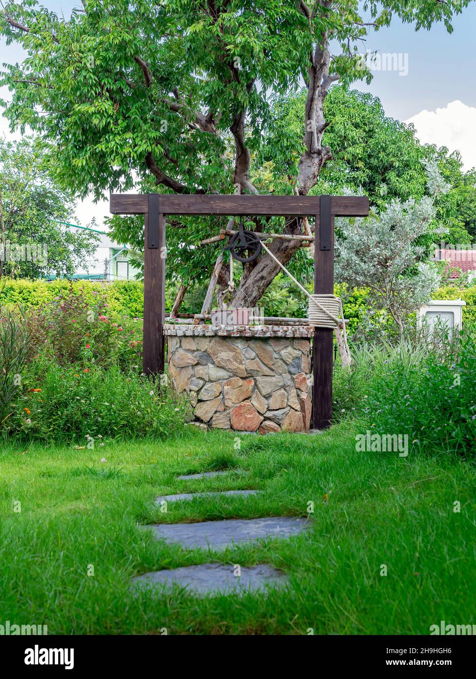 Beautiful artesian well made by stones and wheel pulley with metal ...
