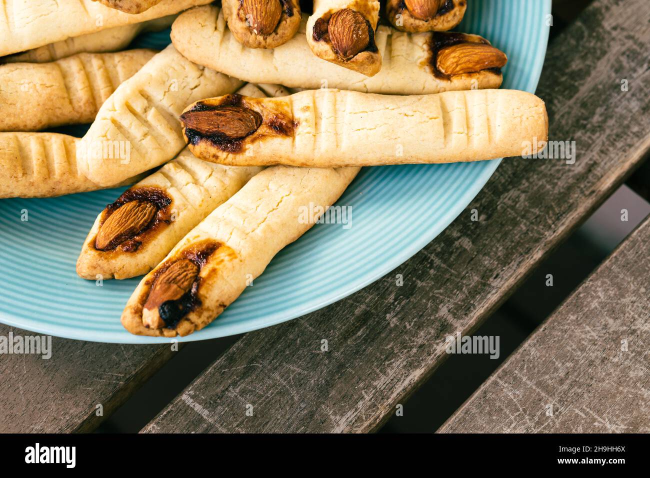 Shot of finger shaped butter cookies with dough and almonds as nails in ...