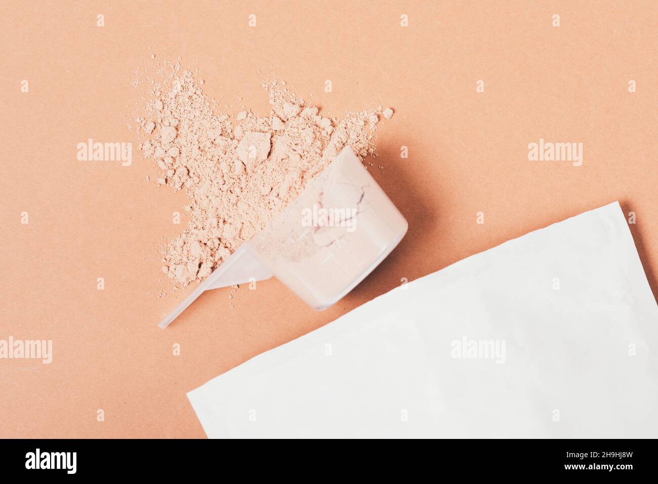 Chocolate whey protein powder and paper package on brown background ...