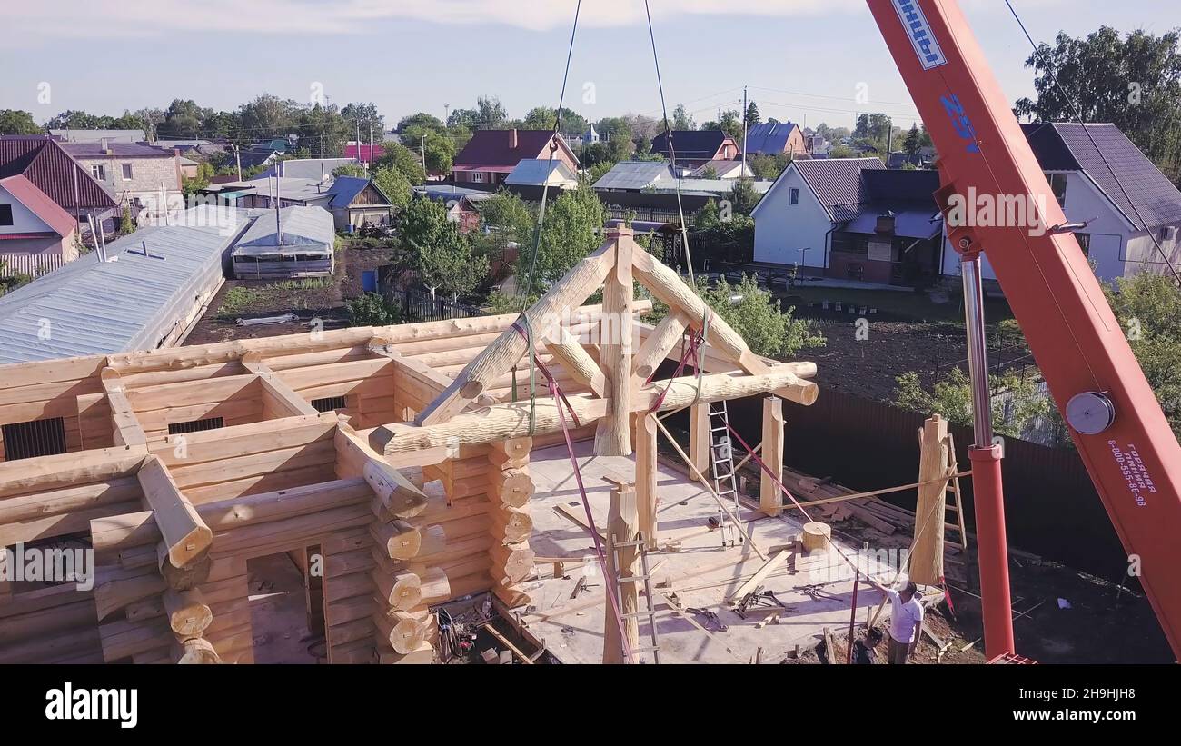 Workers with crane lift wooden structure of house. Clip. Top view of ...