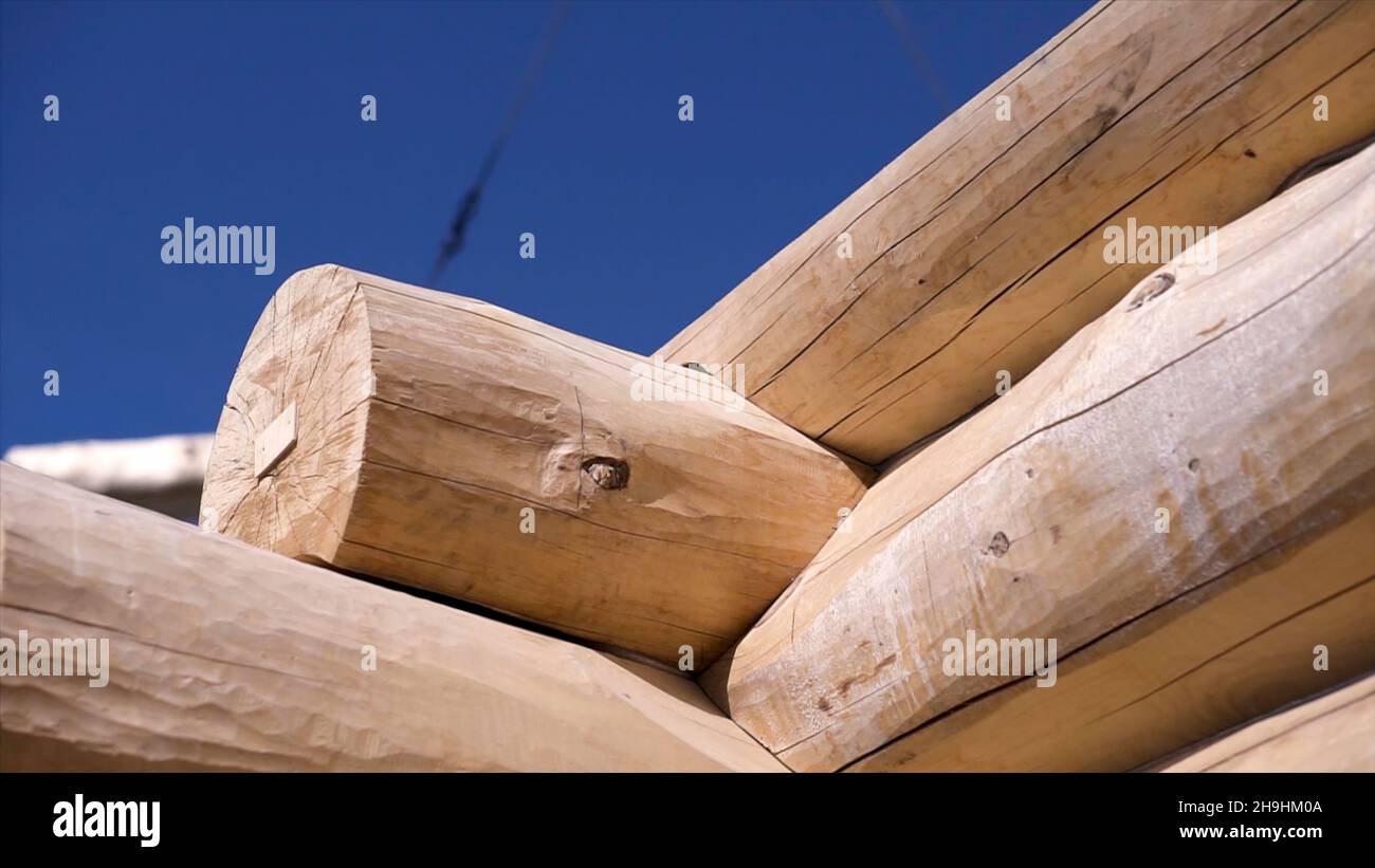 Close-up of wooden house and lifting crane with timber. Clip. Wooden ...