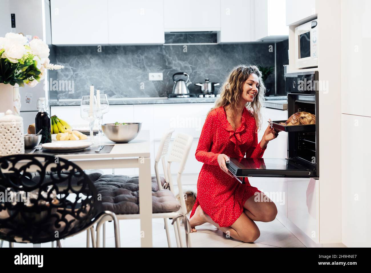 woman housewife cooks chicken bakes in the oven Stock Photo - Alamy
