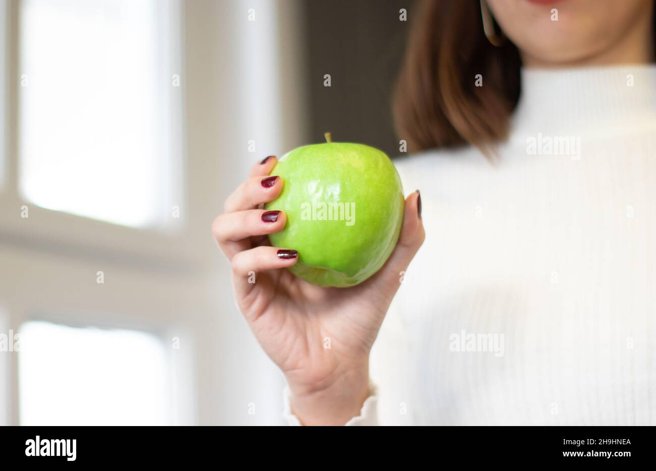 green apple standing in woman's hand, on isolated background Stock ...