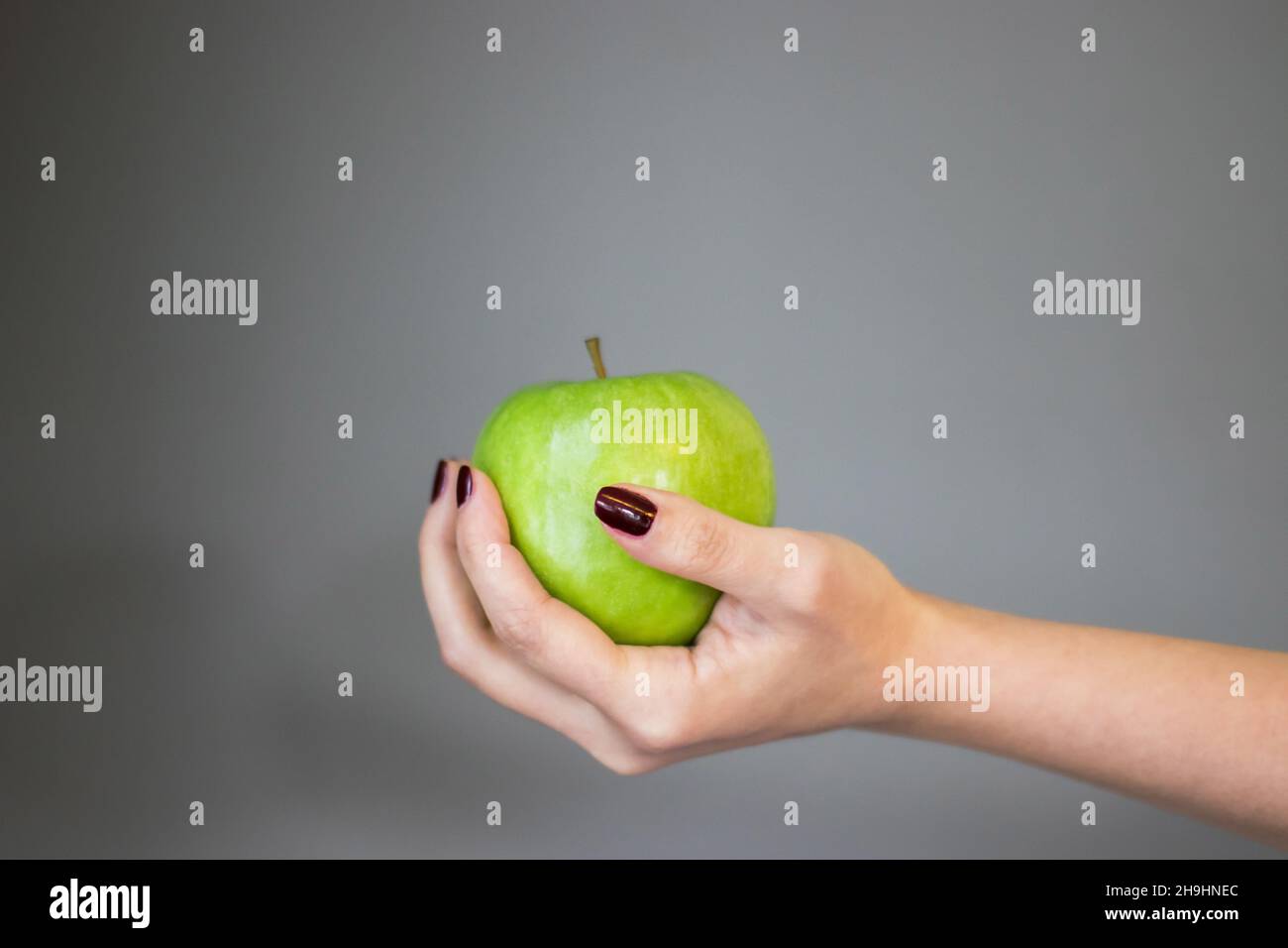green apple standing in woman's hand, on isolated background Stock ...
