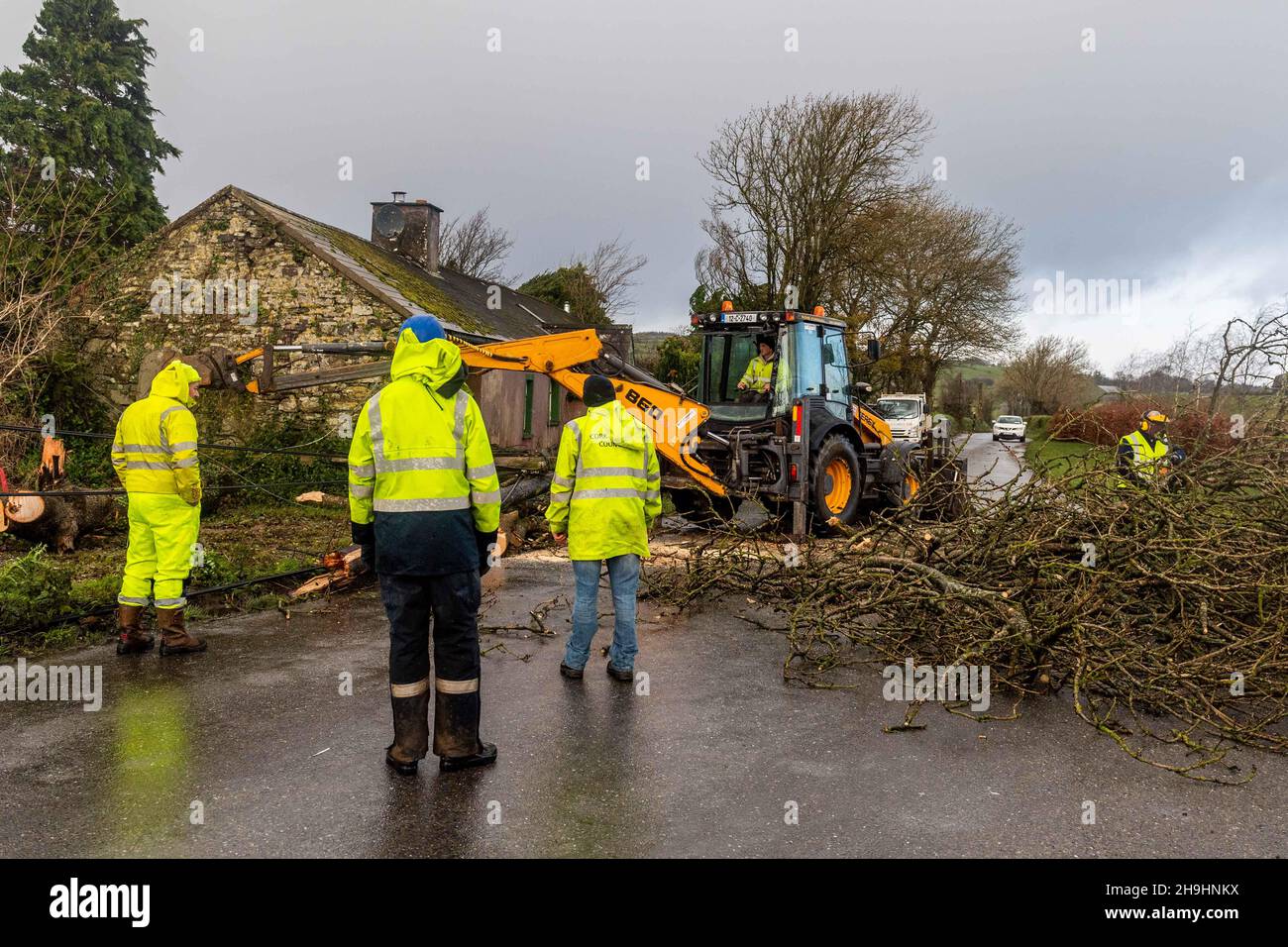 Cork County Council and ESB employees help to clear the road and ...