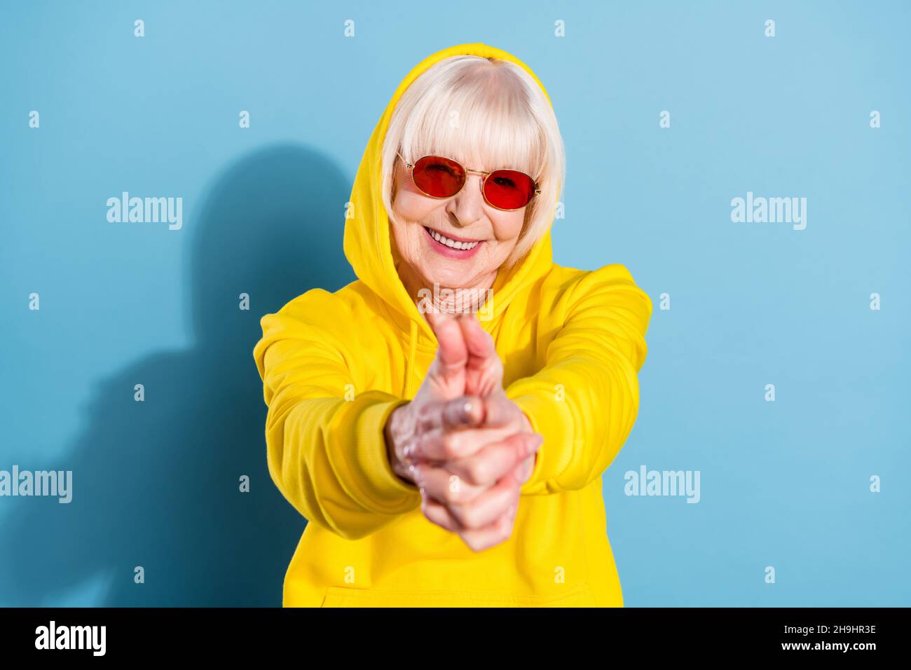 Photo of positive old charming woman hold fingers gun shoot you smile ...