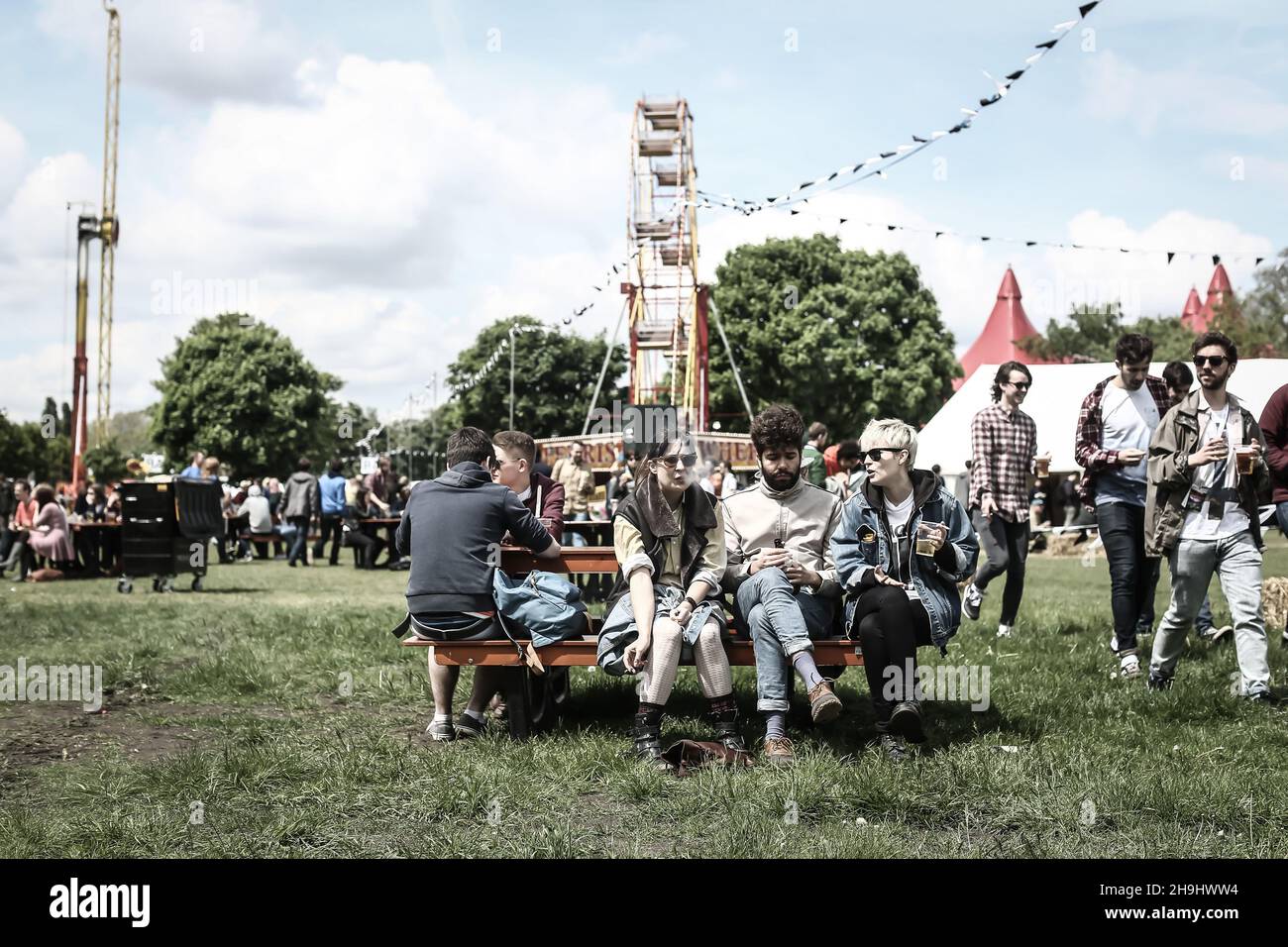 Festival goers sit on a bench at the Field Day Festival in Victoria ...