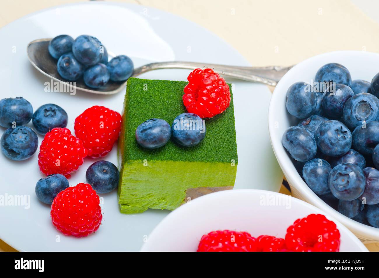 green tea matcha mousse cake with raspberries and blueberries on top ...