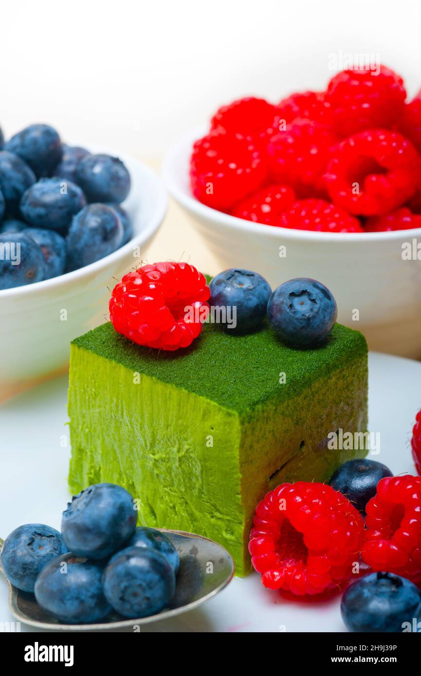 green tea matcha mousse cake with raspberries and blueberries on top ...